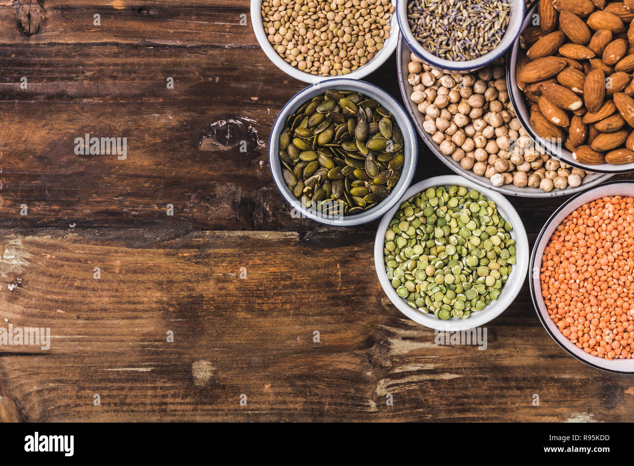 Composition of different types of legumes in bowls on wooden background ...
