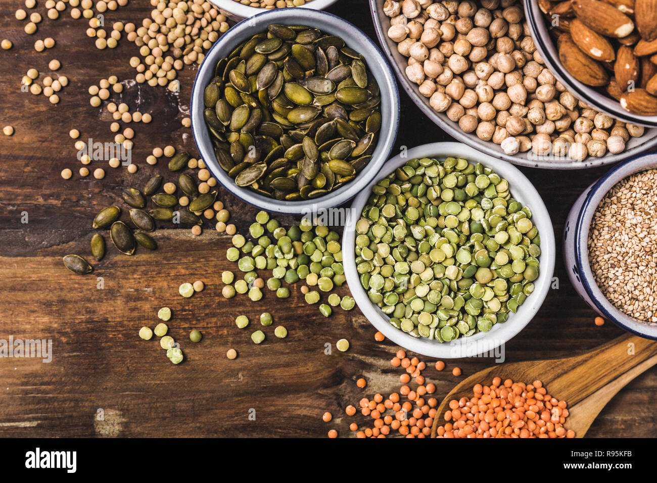 Composition of different types of legumes in bowls on wooden background ...