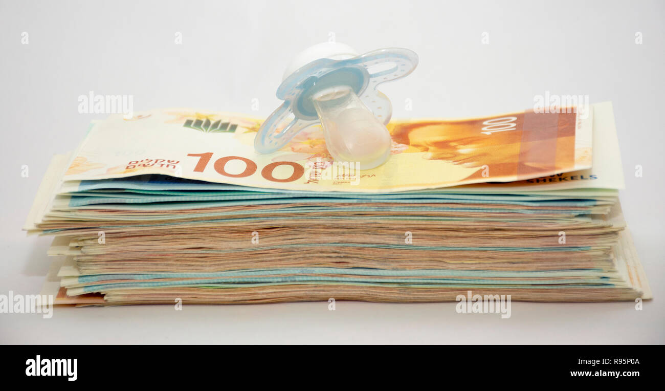 expensive parenting - pacifier on a pile of money Stock Photo - Alamy