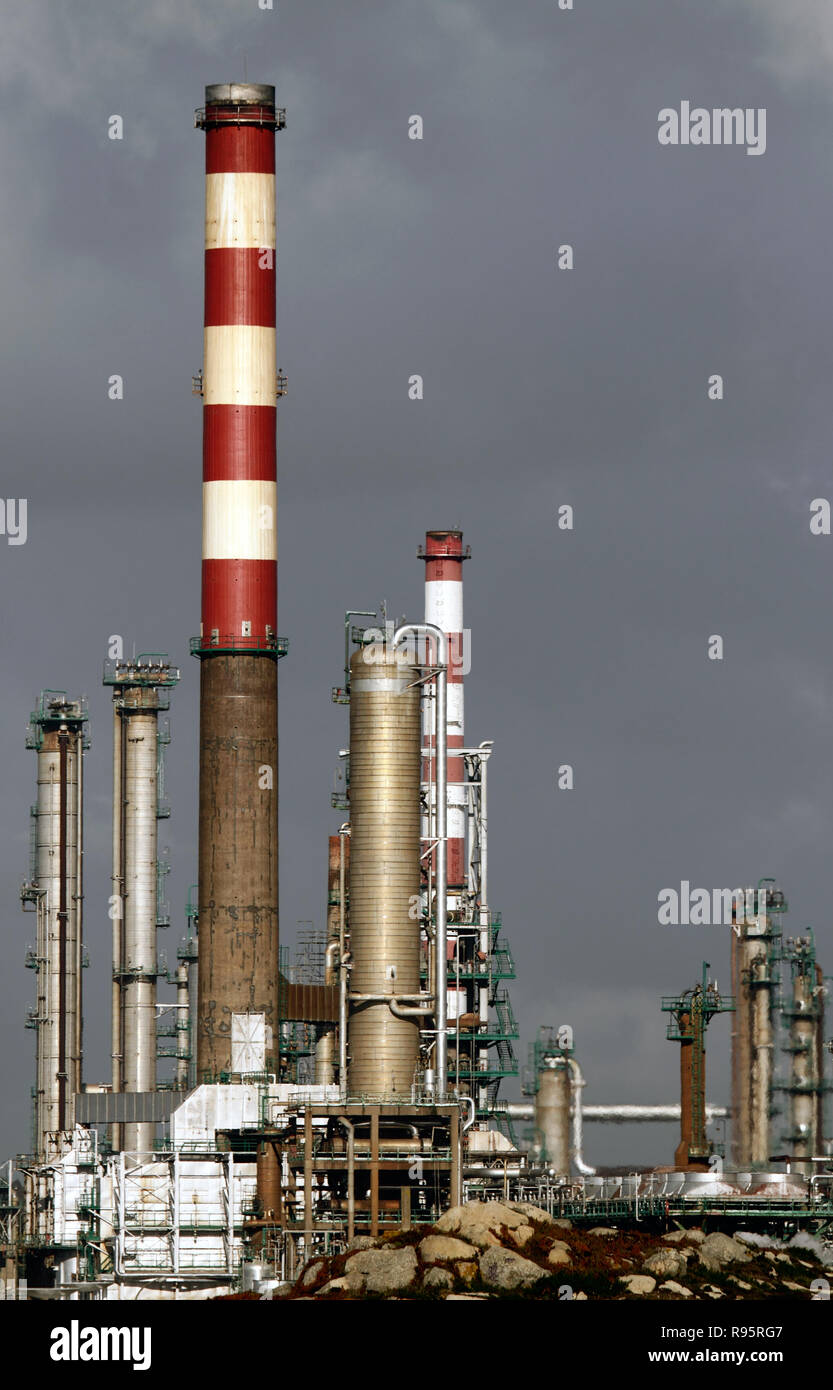 Industrial pipes and chimneys from a big oil refinery seeing steam and ...