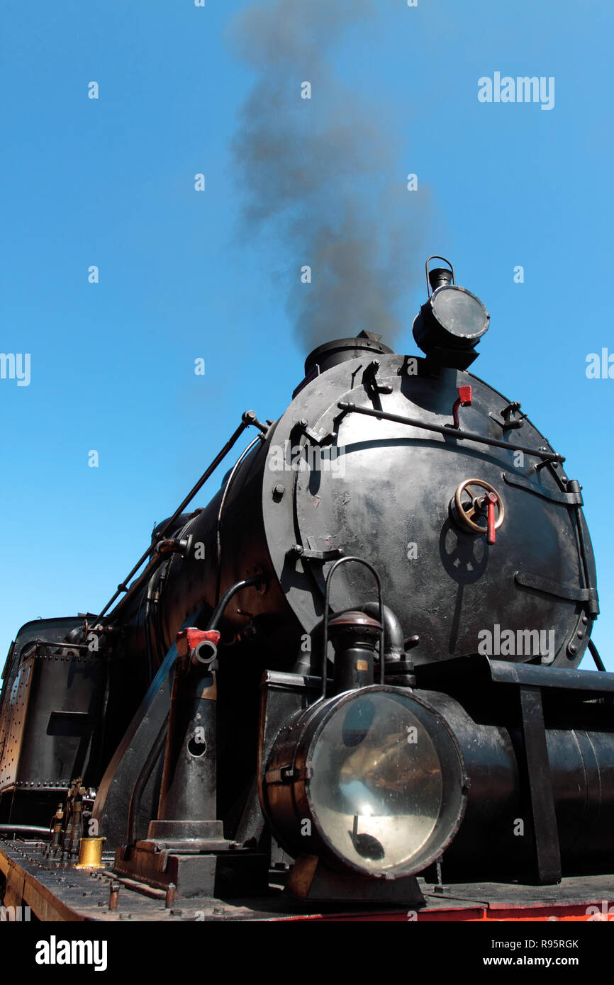 Detail of Vintage steam engine with smoke against blue sky Stock Photo ...