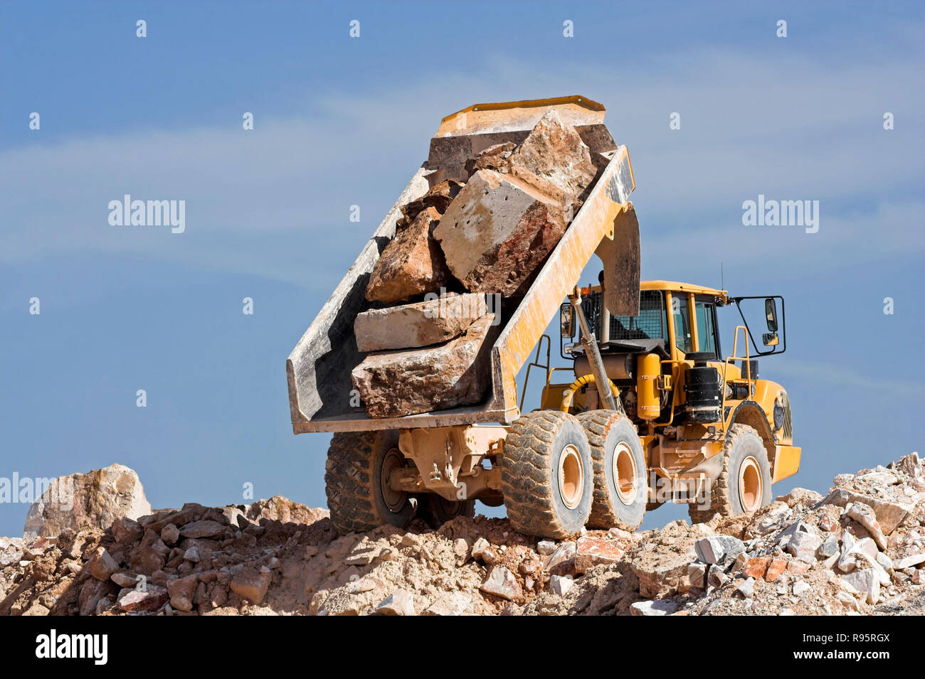 Heavy dump truck against blue sky operating in a marble quarry Stock ...