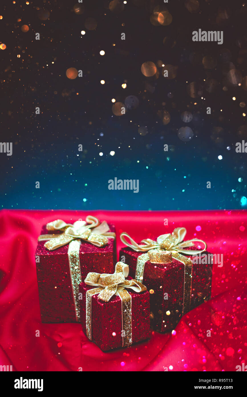 Sparkly red present boxes with Christmas lights and decorations on a ...