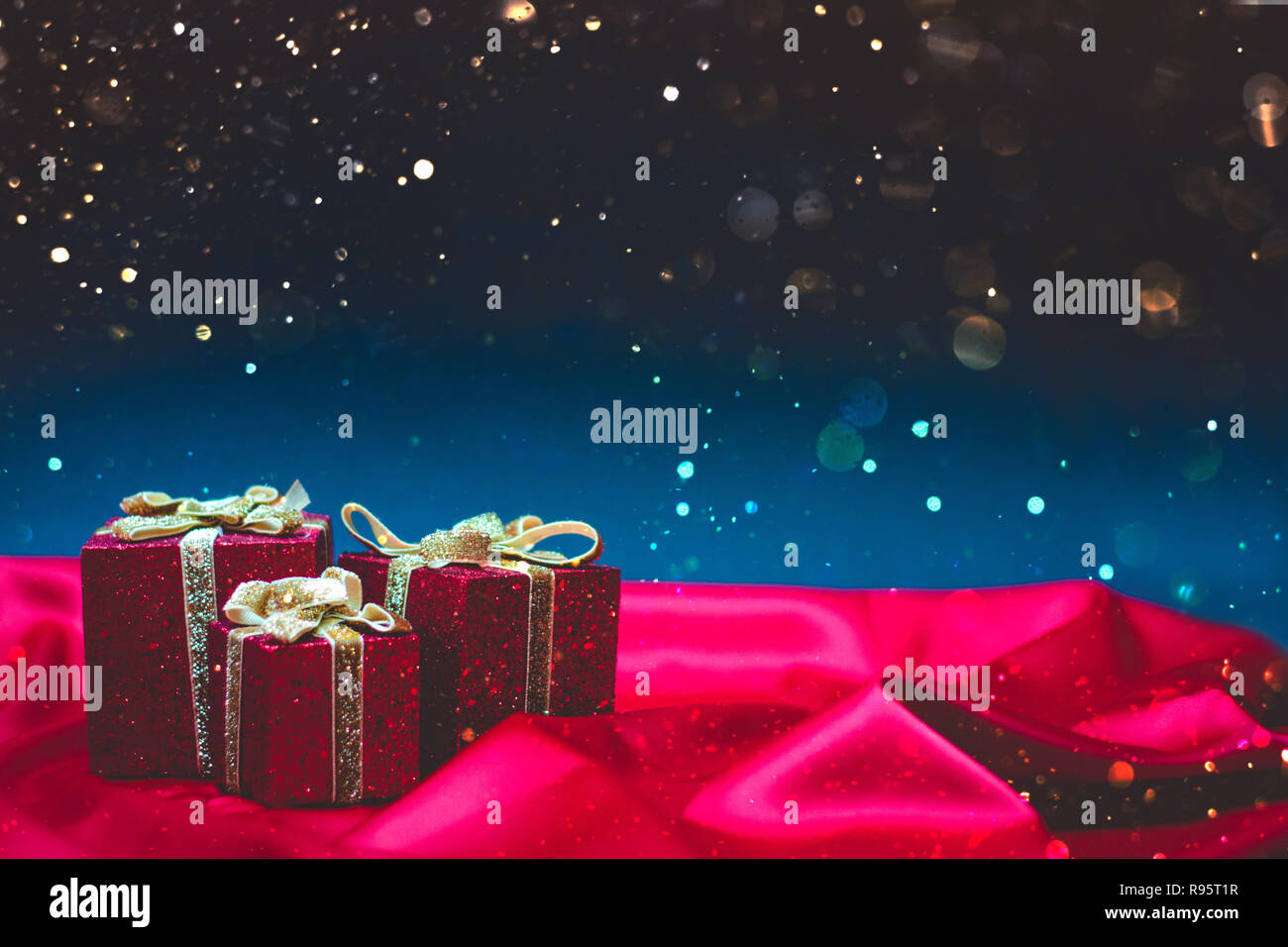 Sparkly red present boxes with Christmas lights and decorations on a ...