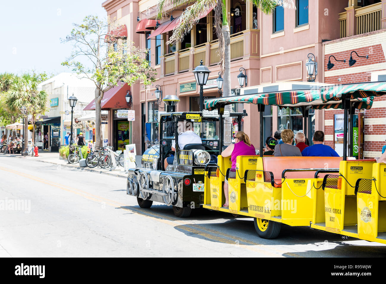 Key West, USA - May 1, 2018: People, tourists riding yellow black conch ...