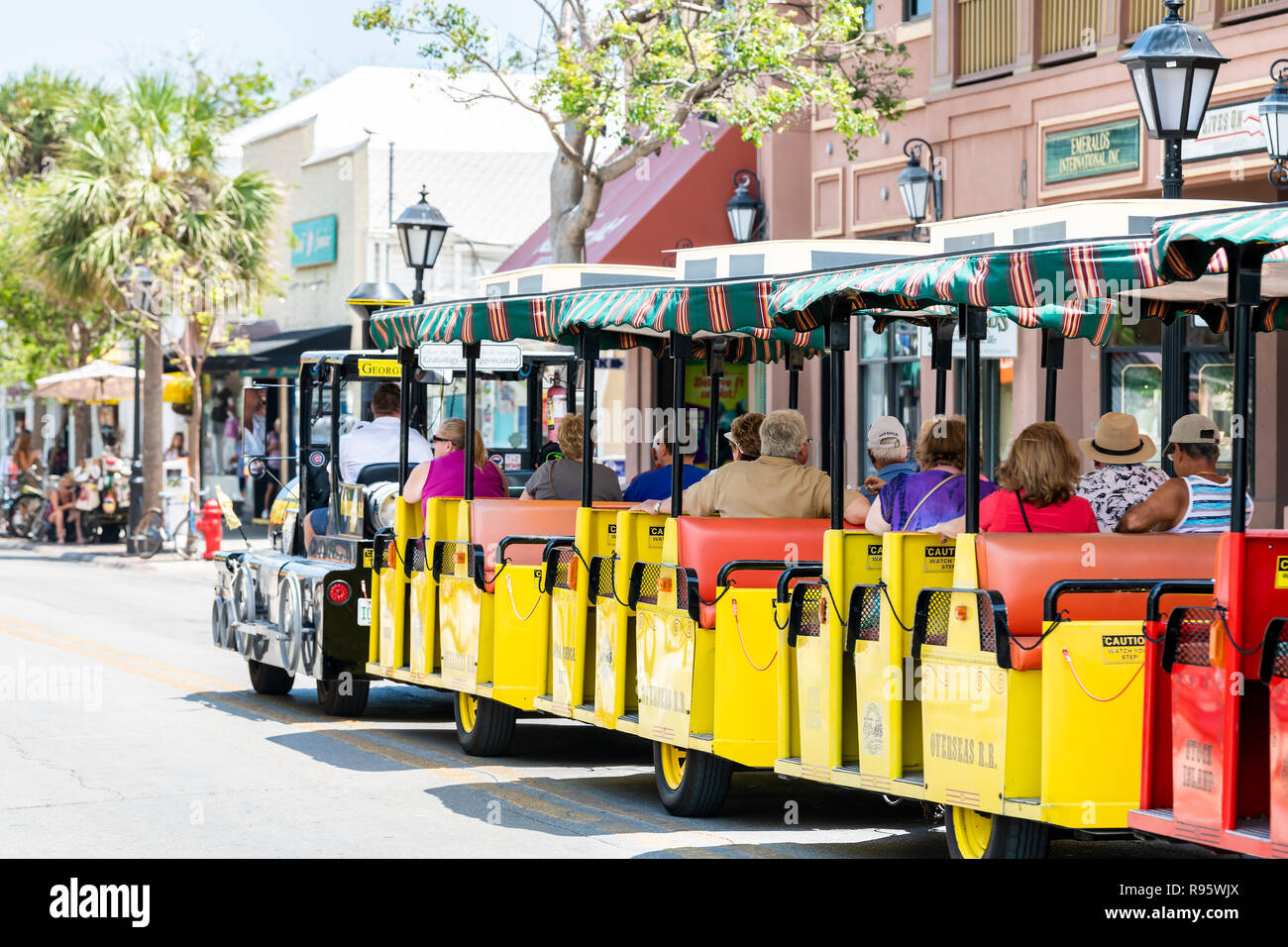 Key West, USA - May 1, 2018: Back of people, tourists riding yellow ...