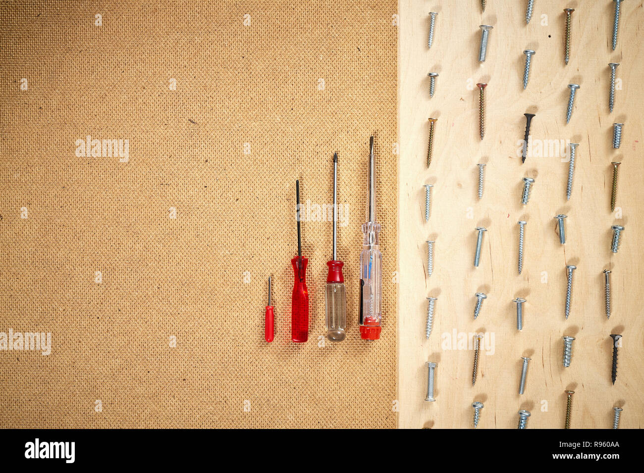 pattern background of various screws and screwdriver on a wooden work ...