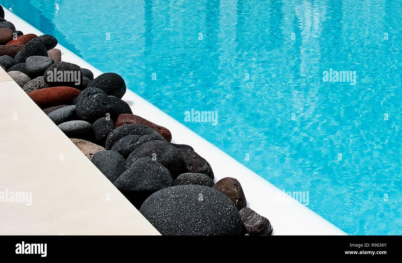 Colorful volcanic stones next to a swimming pool Stock Photo - Alamy