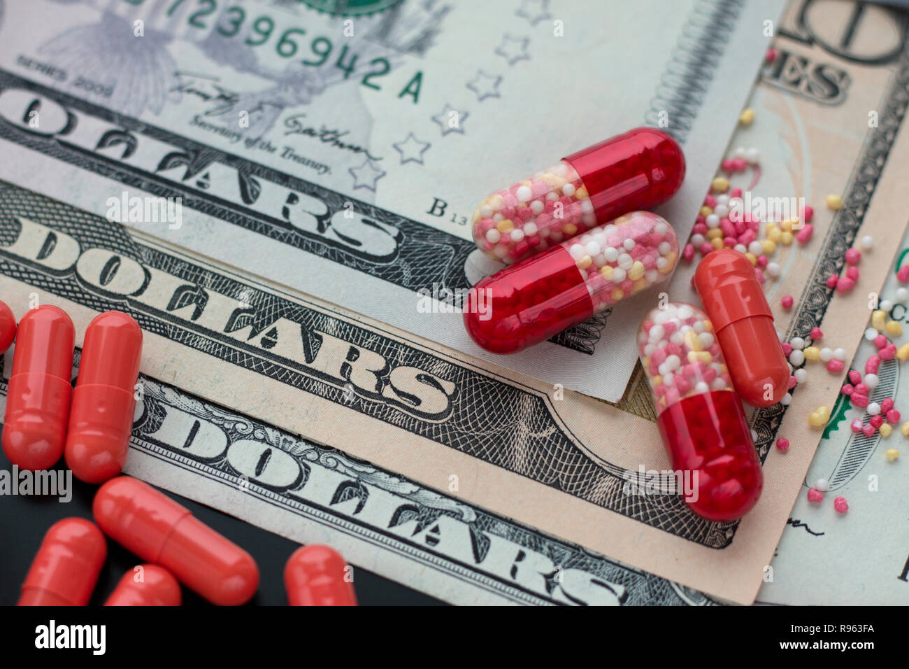 Red capsules or pills on dollar bills. Concept of expensive therapy ...