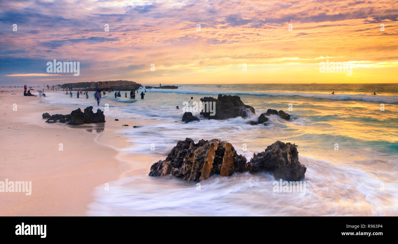 Perth beach at sunset. People in the water on a balmy summer evening at ...