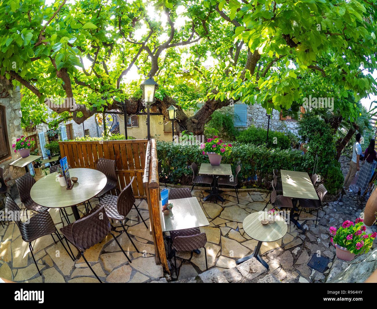Traditional restaurant terrace inside Eze village with tables and ...