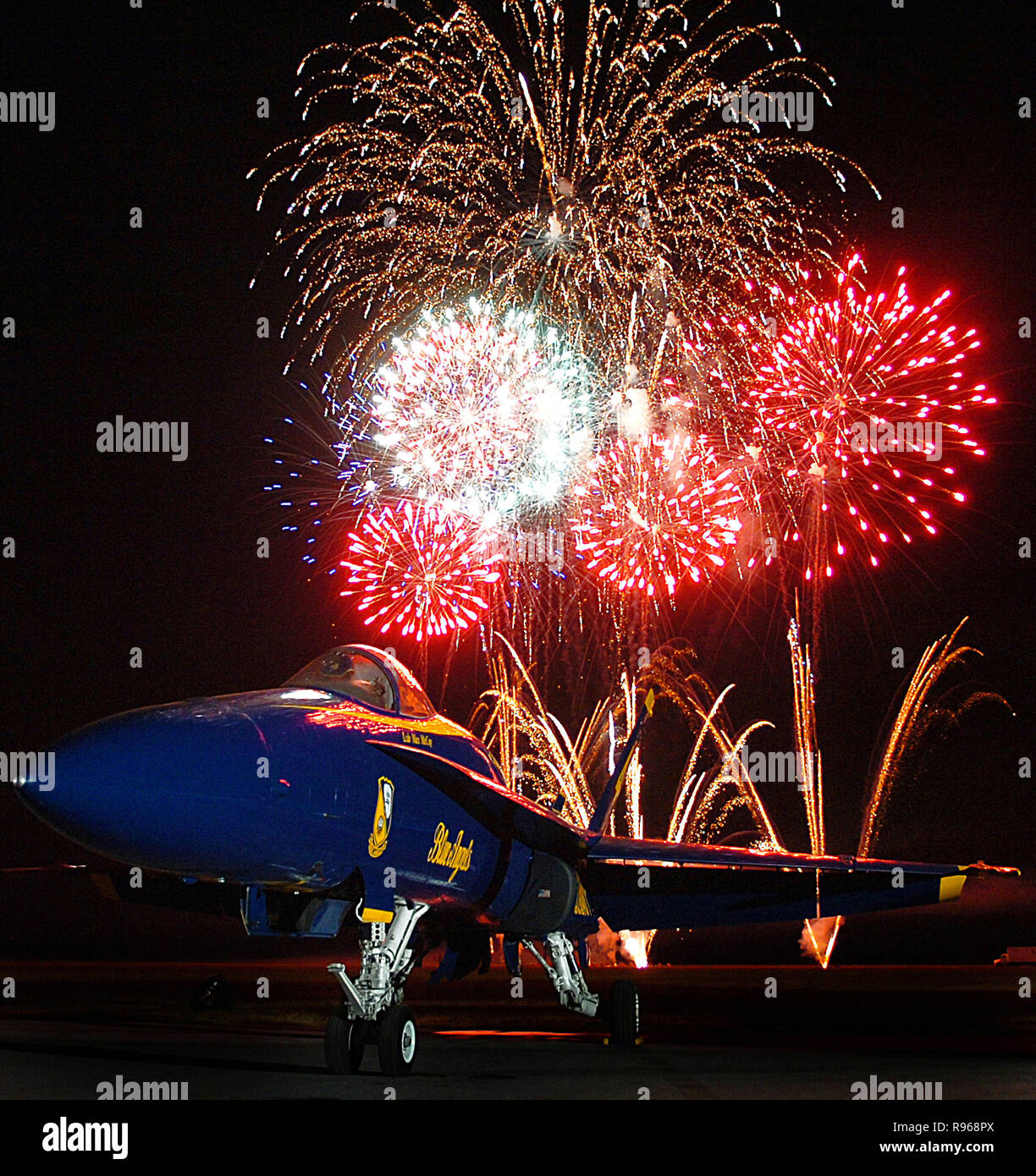 Fireworks explode and highlight an F/A-18A Hornet, assigned to the U.S ...