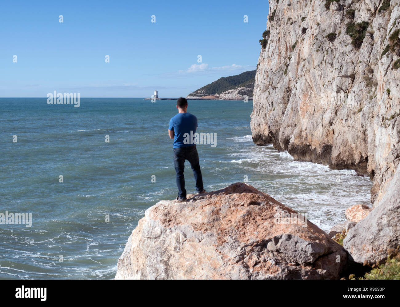 Man on cliff overlooking sea hi-res stock photography and images - Alamy