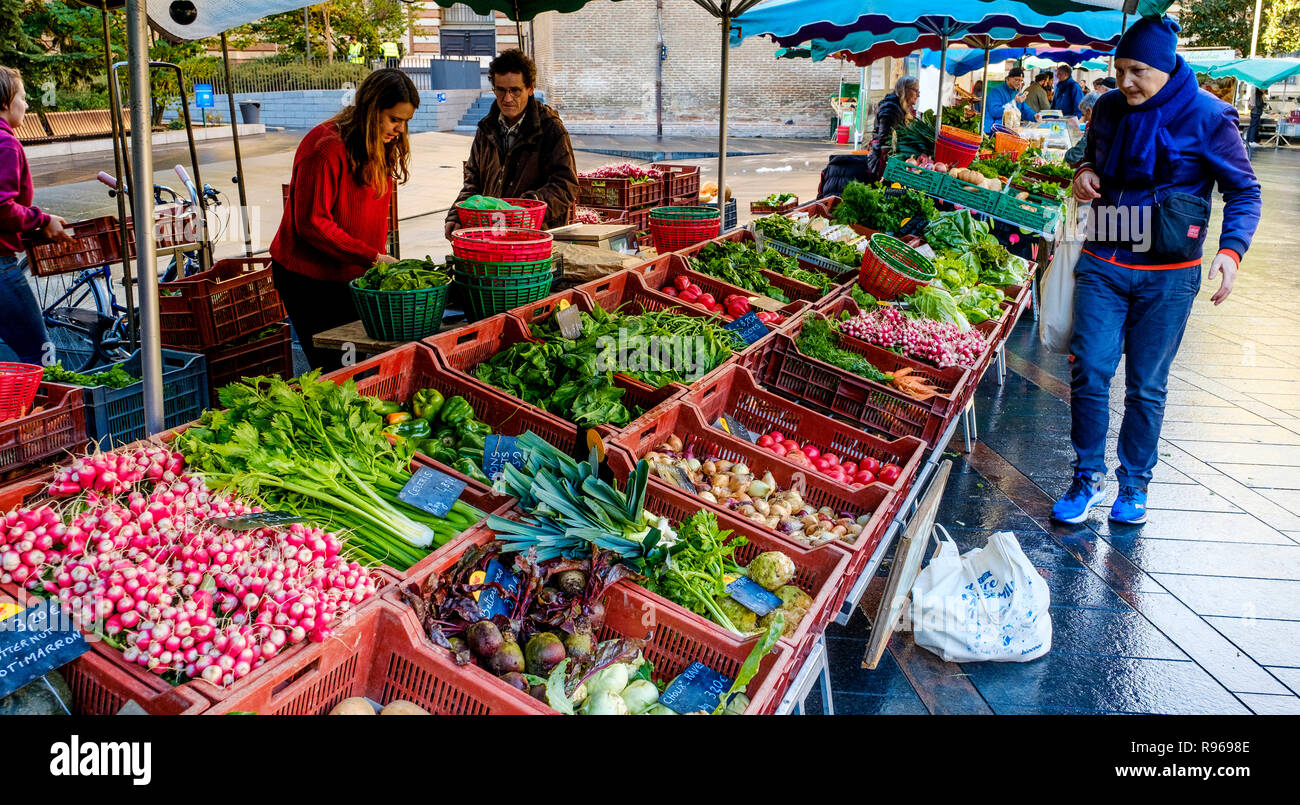 Shoppers buying vegetables from a street market in the Square Charles ...