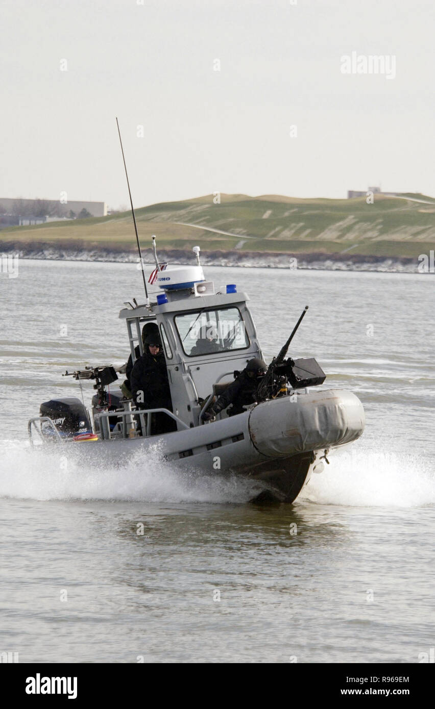 A Navy small craft patrols the exclusion area of the harbor in ...