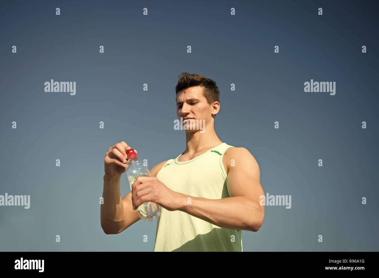 Sport and fitness concept. Man with water bottle in muscular hands ...