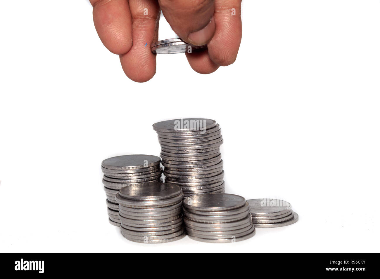 A businessman putting coins over a stack of coins. Financial, economy ...
