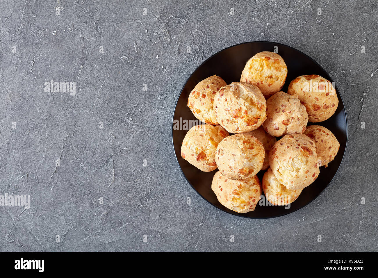 overhead view of Gougeres, cheese puffs balls on a black plate ...