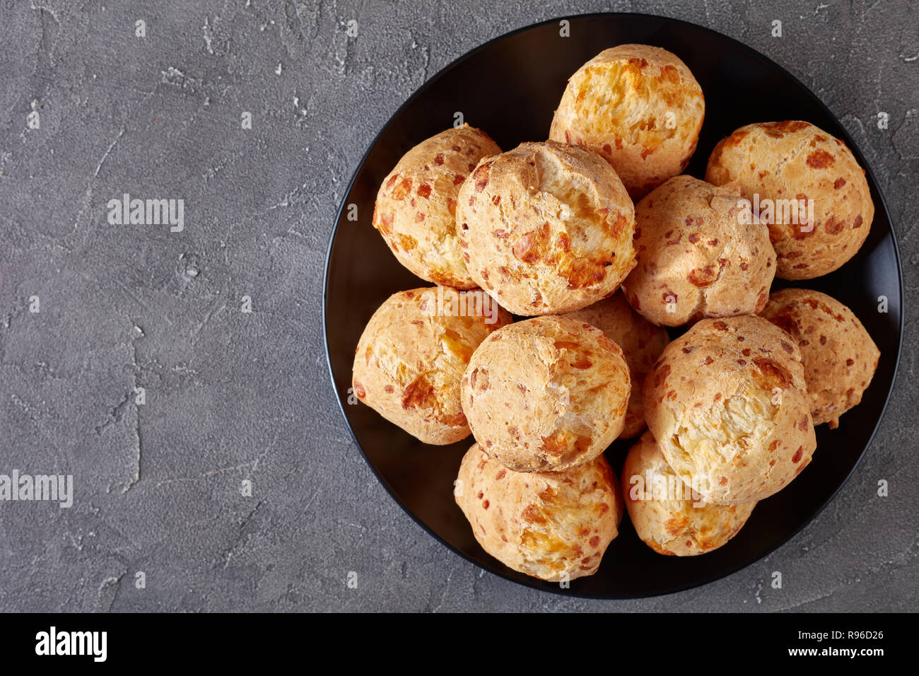 overhead view of Gougeres, cheese puffs balls on a black plate ...
