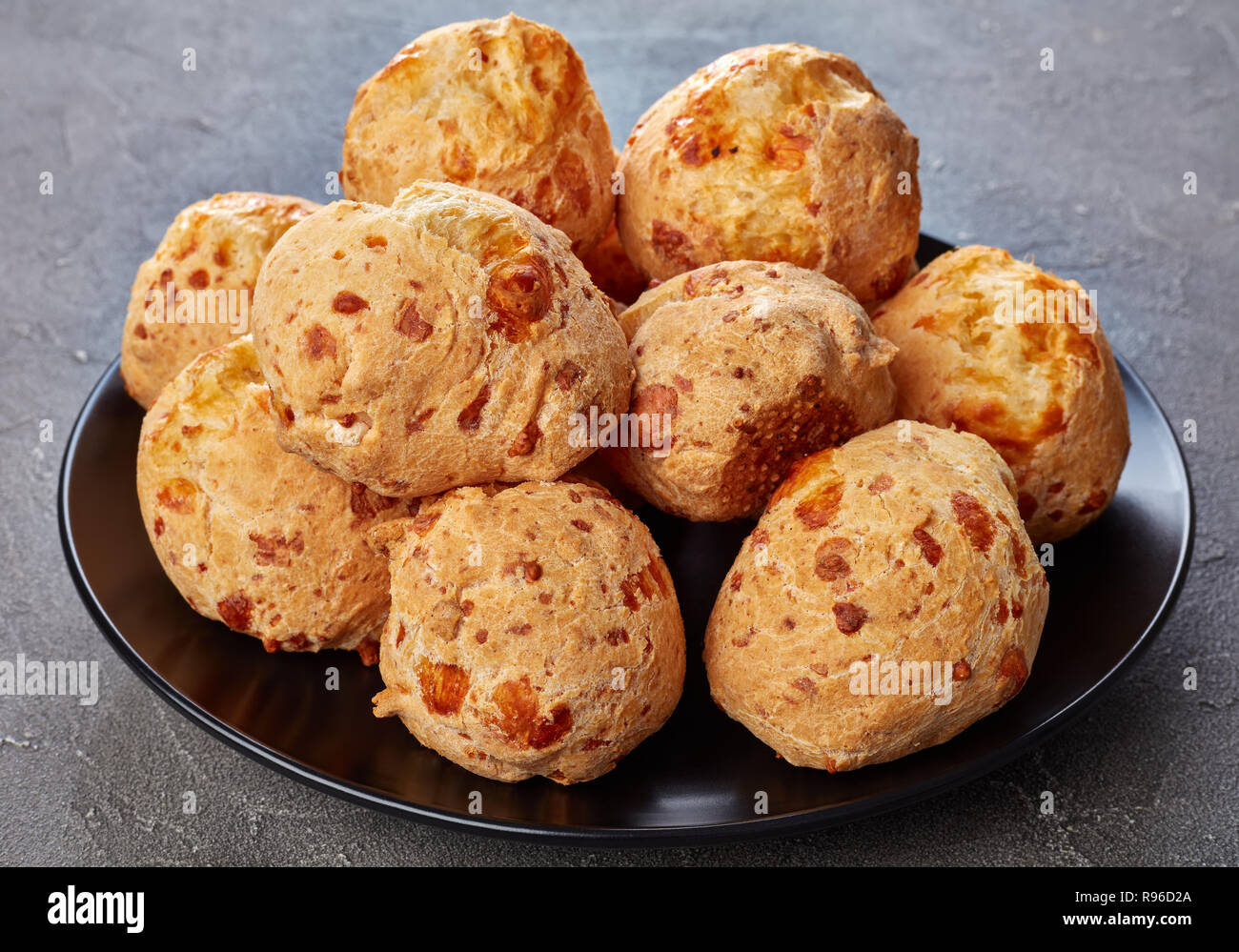 delicious crispy Gougeres, cheese puffs balls on a black plate ...