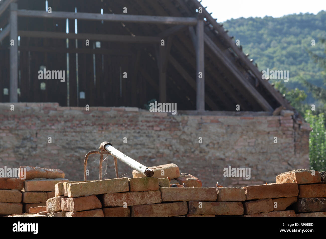 Old house demolition. Reusable bricks put in pile with a pitchfork ...