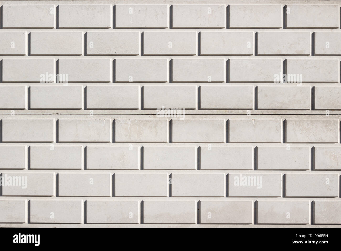 Grey concrete fence with brick shaped texture. The fence was assembled ...