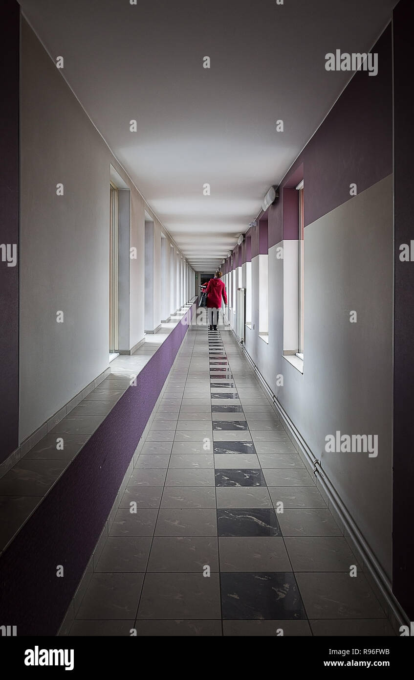 A long corridor - the photo of a perspective with a person walking down ...