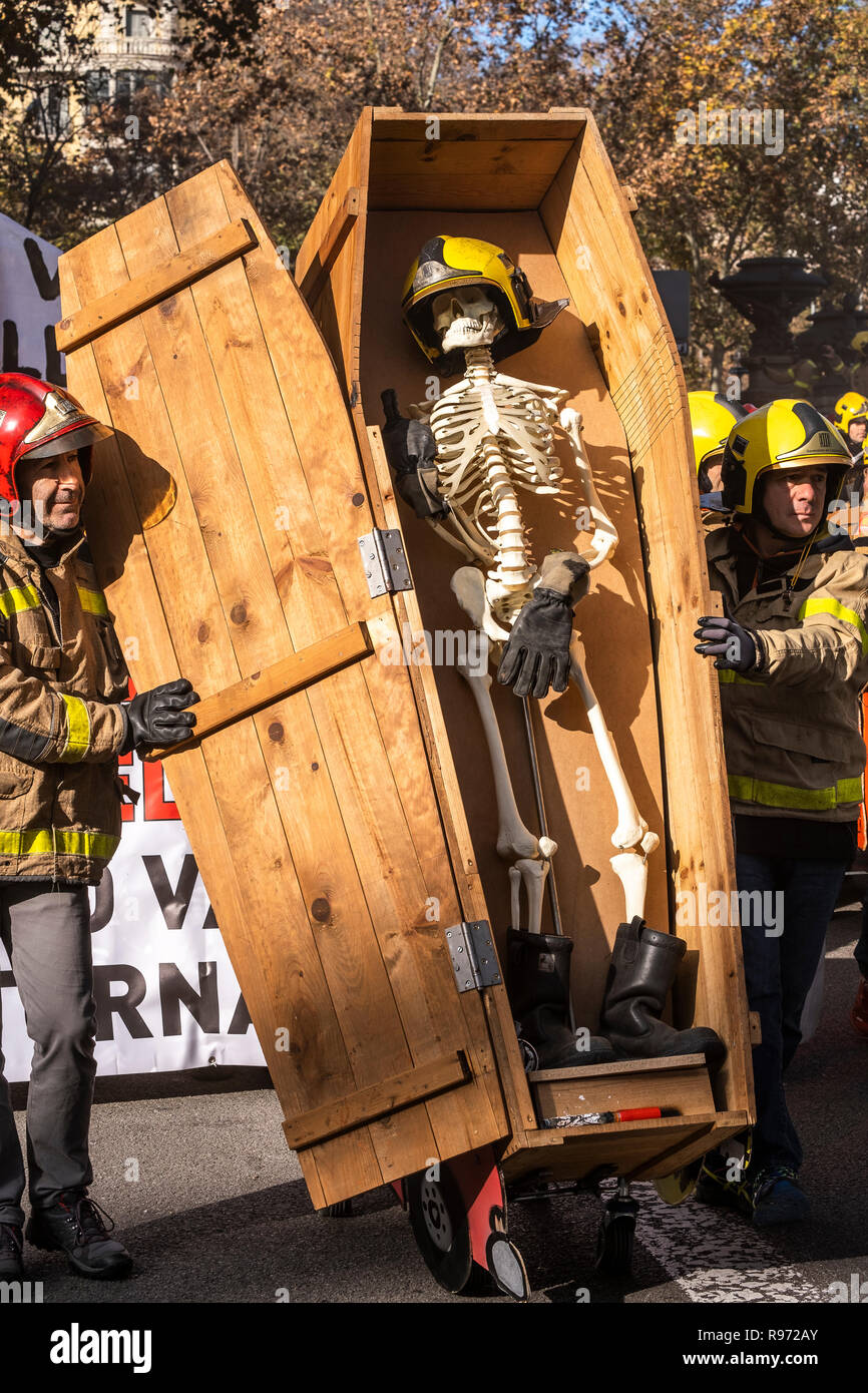 Two firefighters are seen carrying a coffin with a plastic skeleton ...