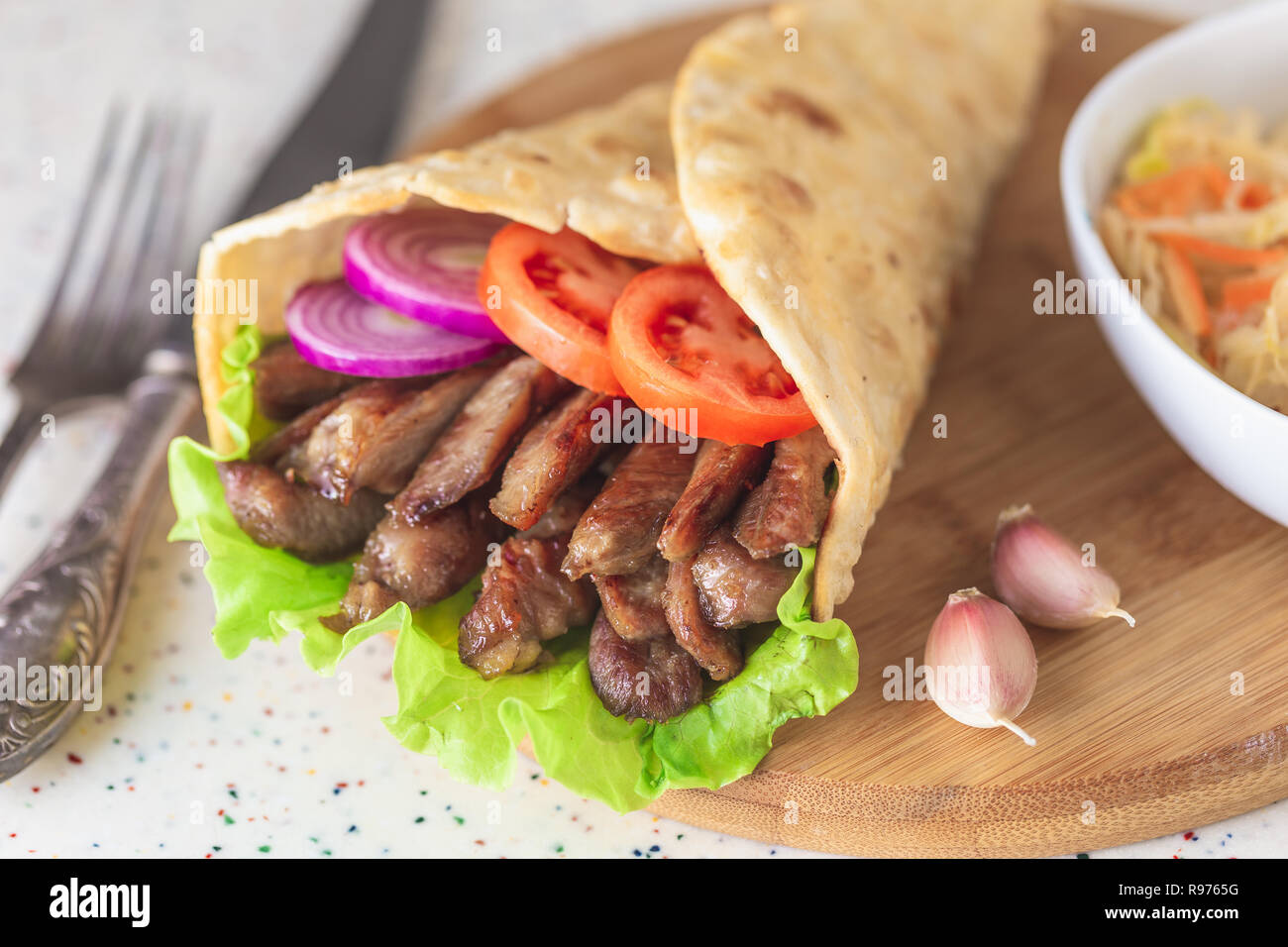 Handmade doner kebab is lying on the white table made of artificial ...