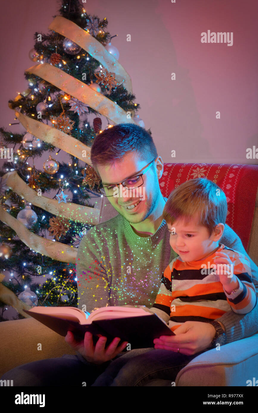 Father and son reading book together on chair Stock Photo - Alamy