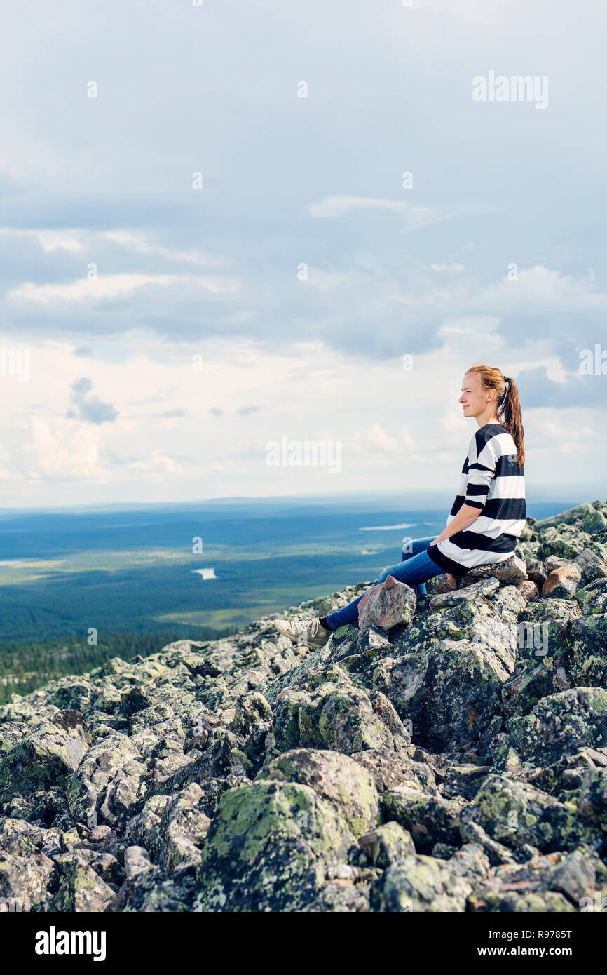 Woman sitting on rocks hi-res stock photography and images - Alamy
