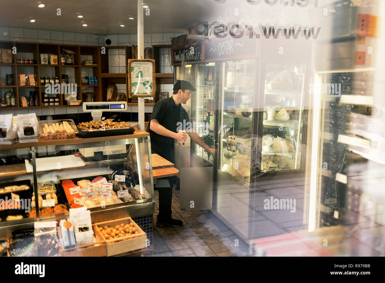 Fishmonger stocking refrigerator in store Stock Photo - Alamy