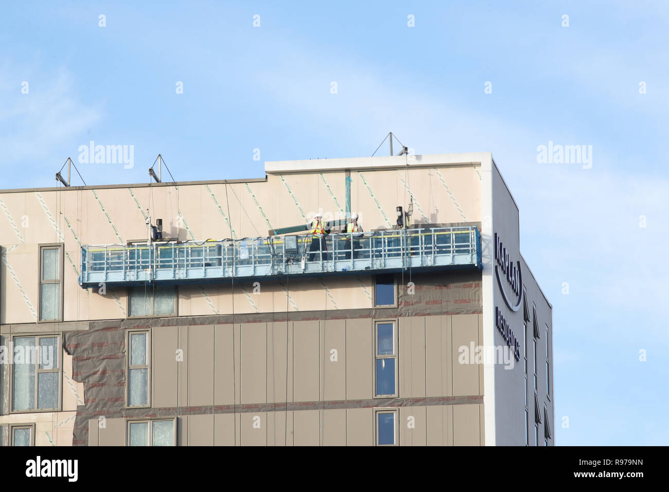 Workmen apply cladding to a building in the Nottingham City Center ...