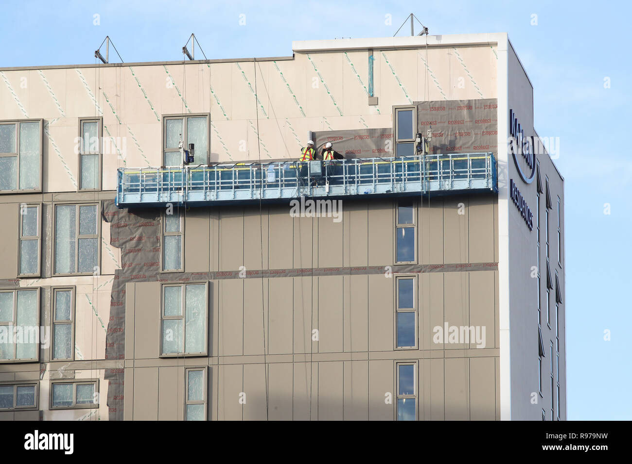 Workmen apply cladding to hi-res stock photography and images - Alamy