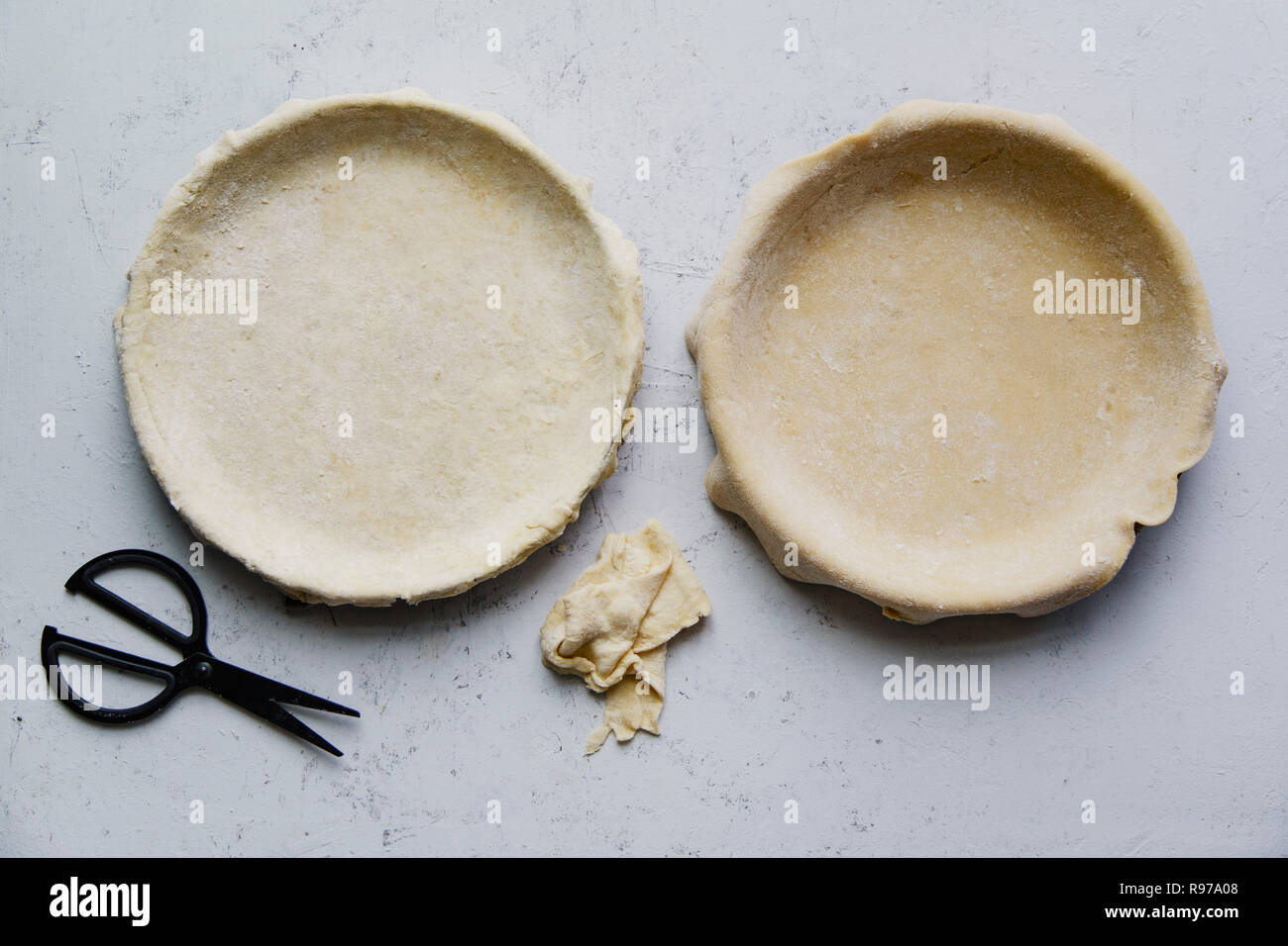 Raw uncooked pie crust in baking pan for two pies on concrete ...