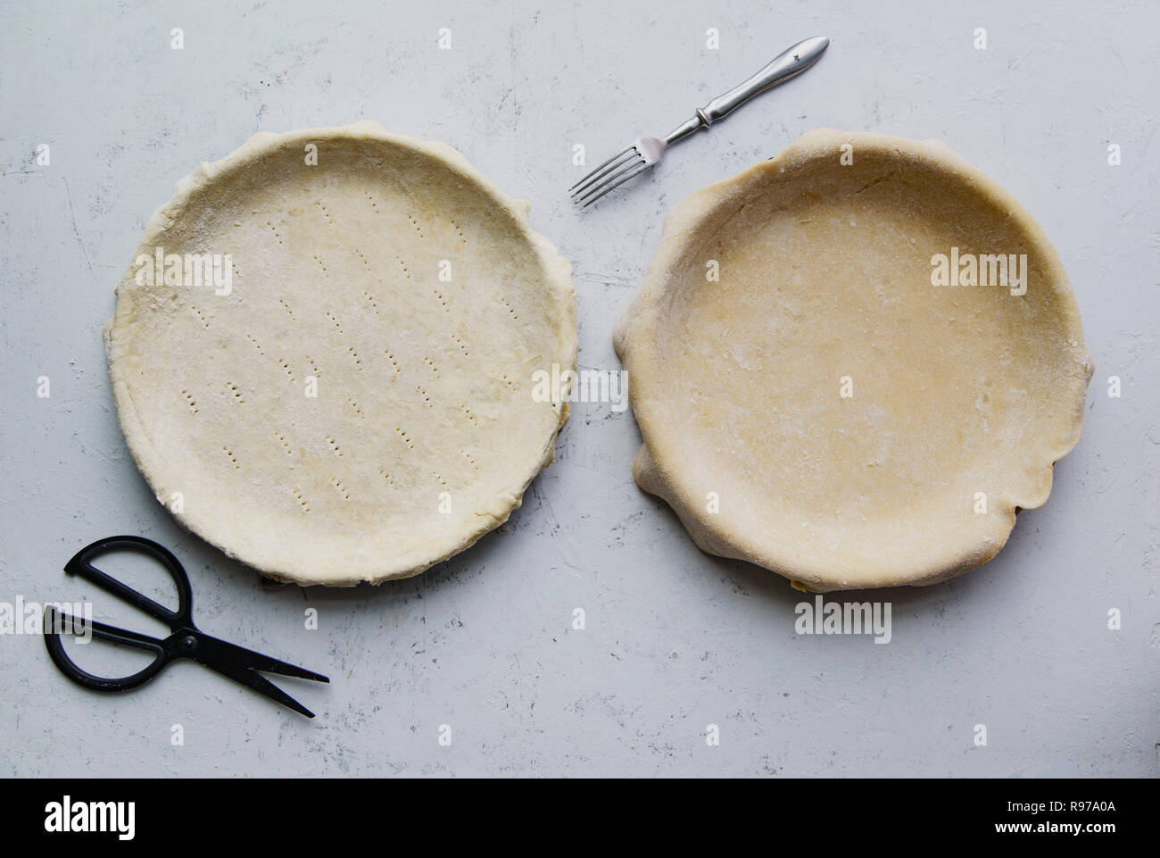 Raw uncooked pie crust in baking pan for two pies on concrete ...