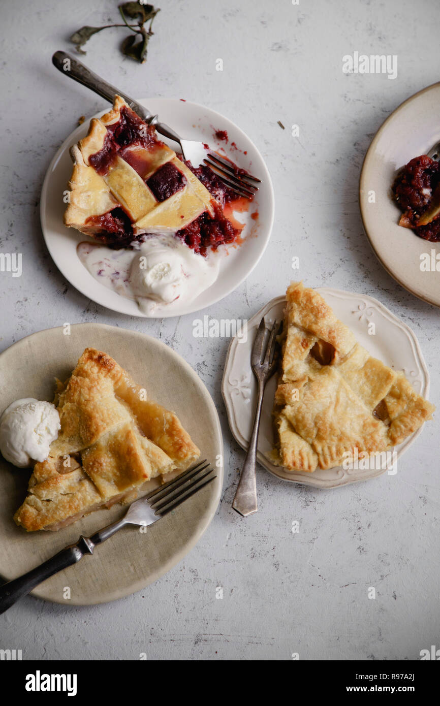 Slices of various pies in little plates. Overhead view, concrete ...