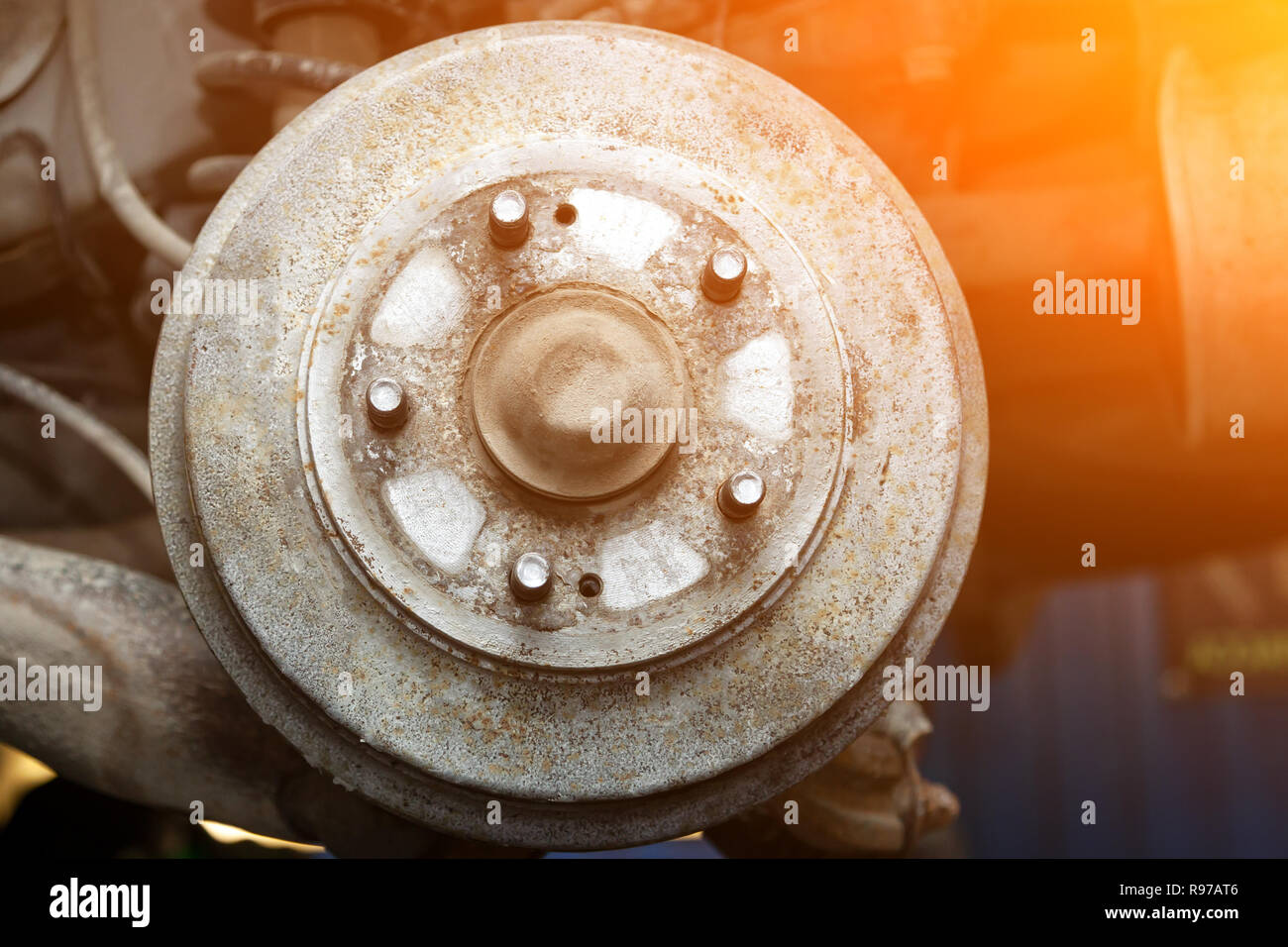 Close-up of heavily worn rear drum brakes on a car raised on a lift in ...