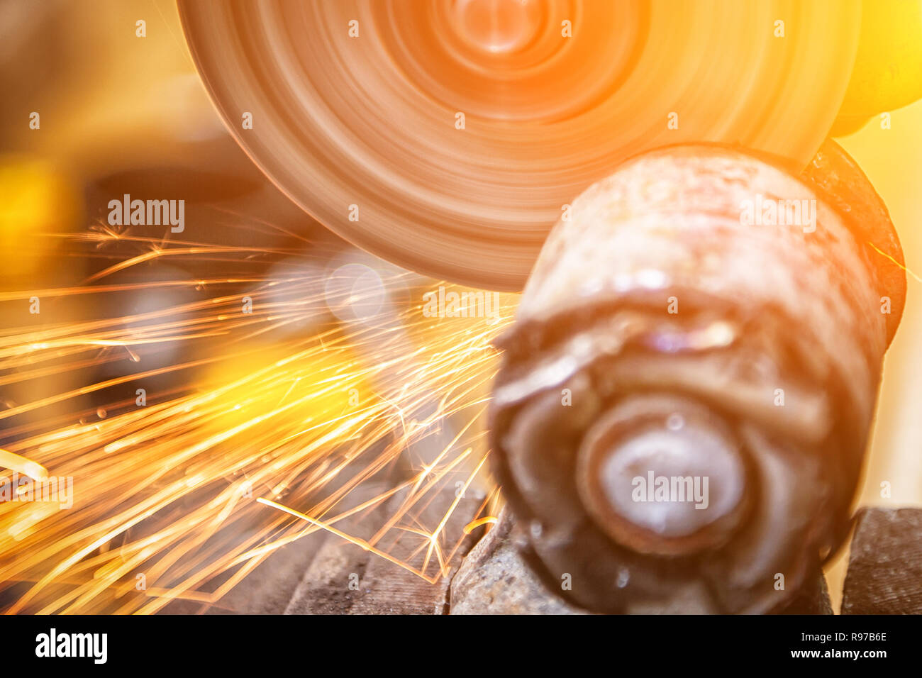 A close-up of a car mechanic using a metal grinder to cut a car silent ...