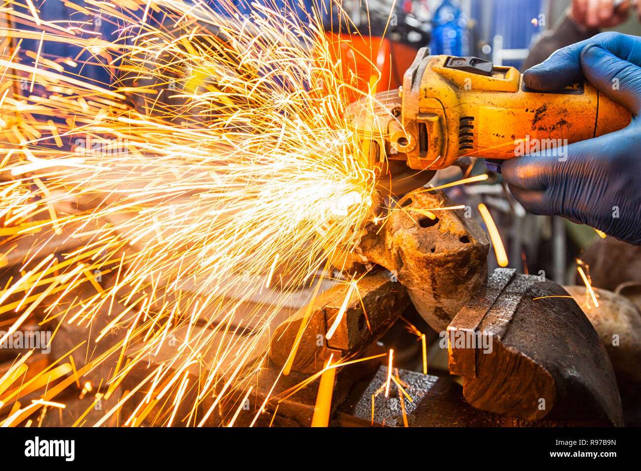 Close-up of a man sawing metal with a hand circular saw on a wooden ...