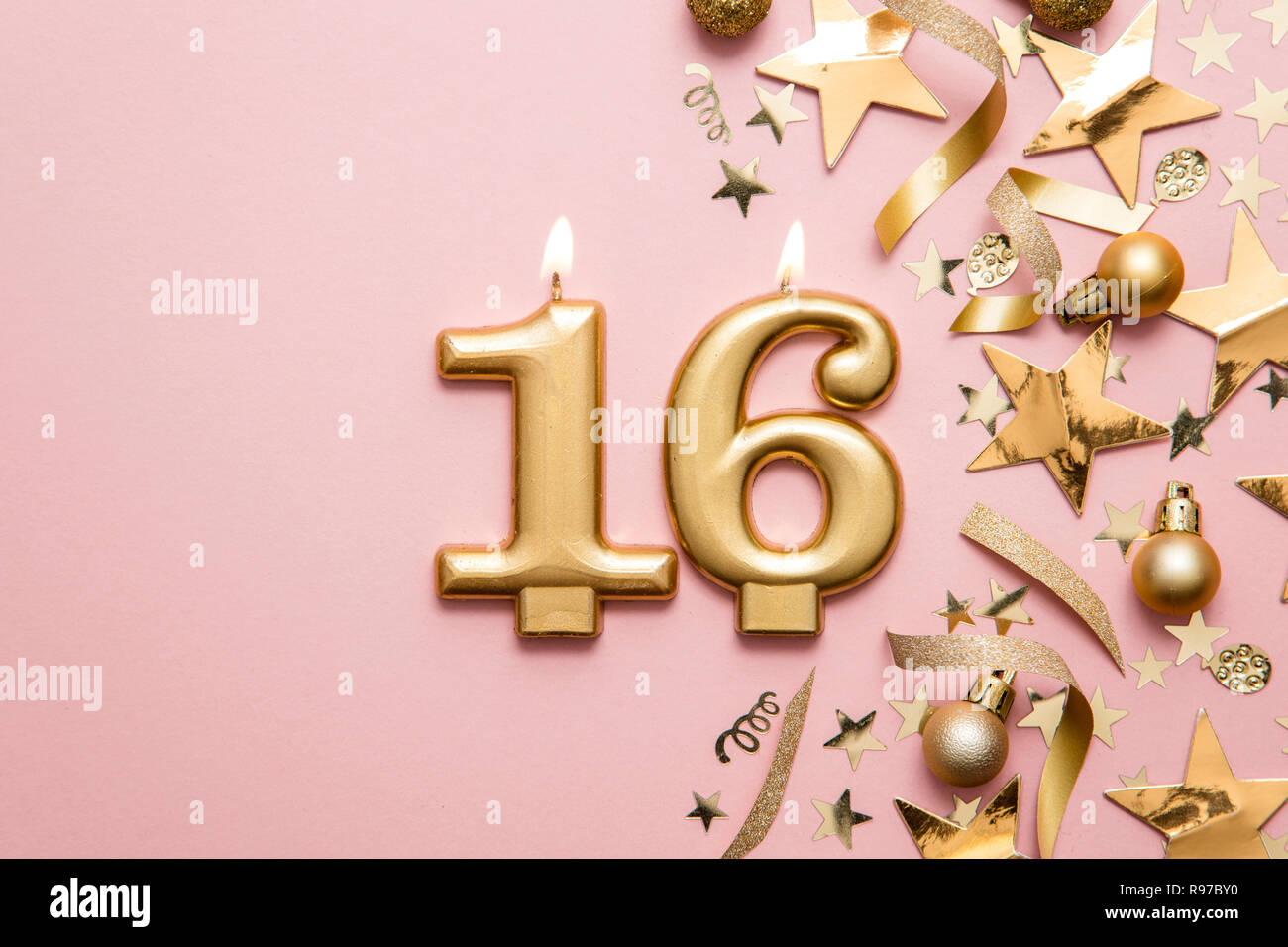 Number 16 gold celebration candle on star and glitter background Stock ...