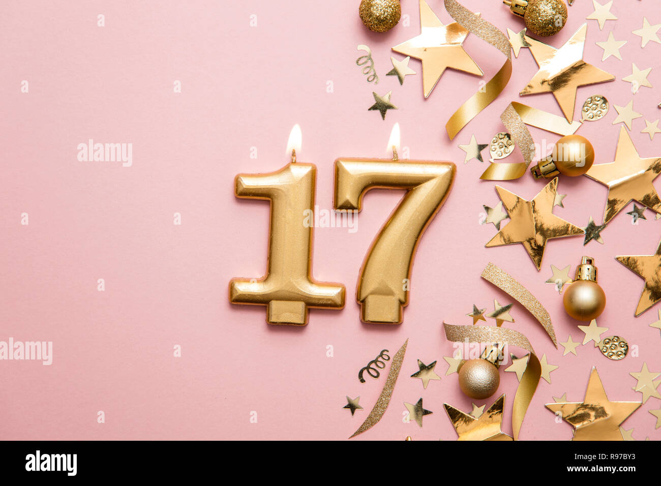 Number 17 gold celebration candle on star and glitter background Stock ...
