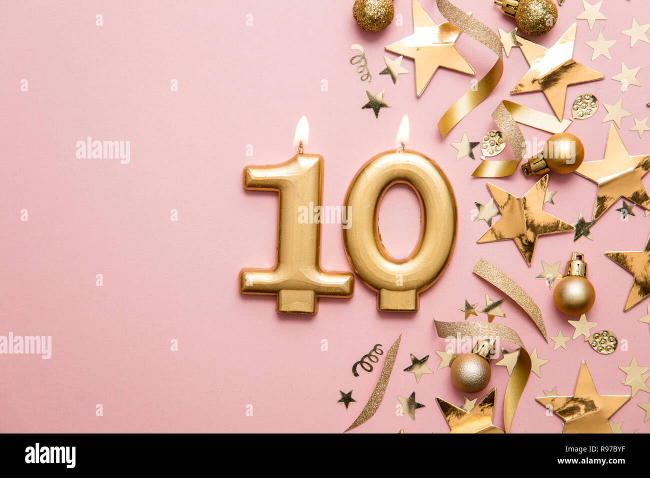 Number 10 gold celebration candle on star and glitter background Stock ...