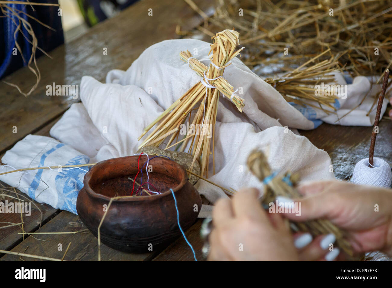 A toy made of straw in the shape of a little human lies on the table ...