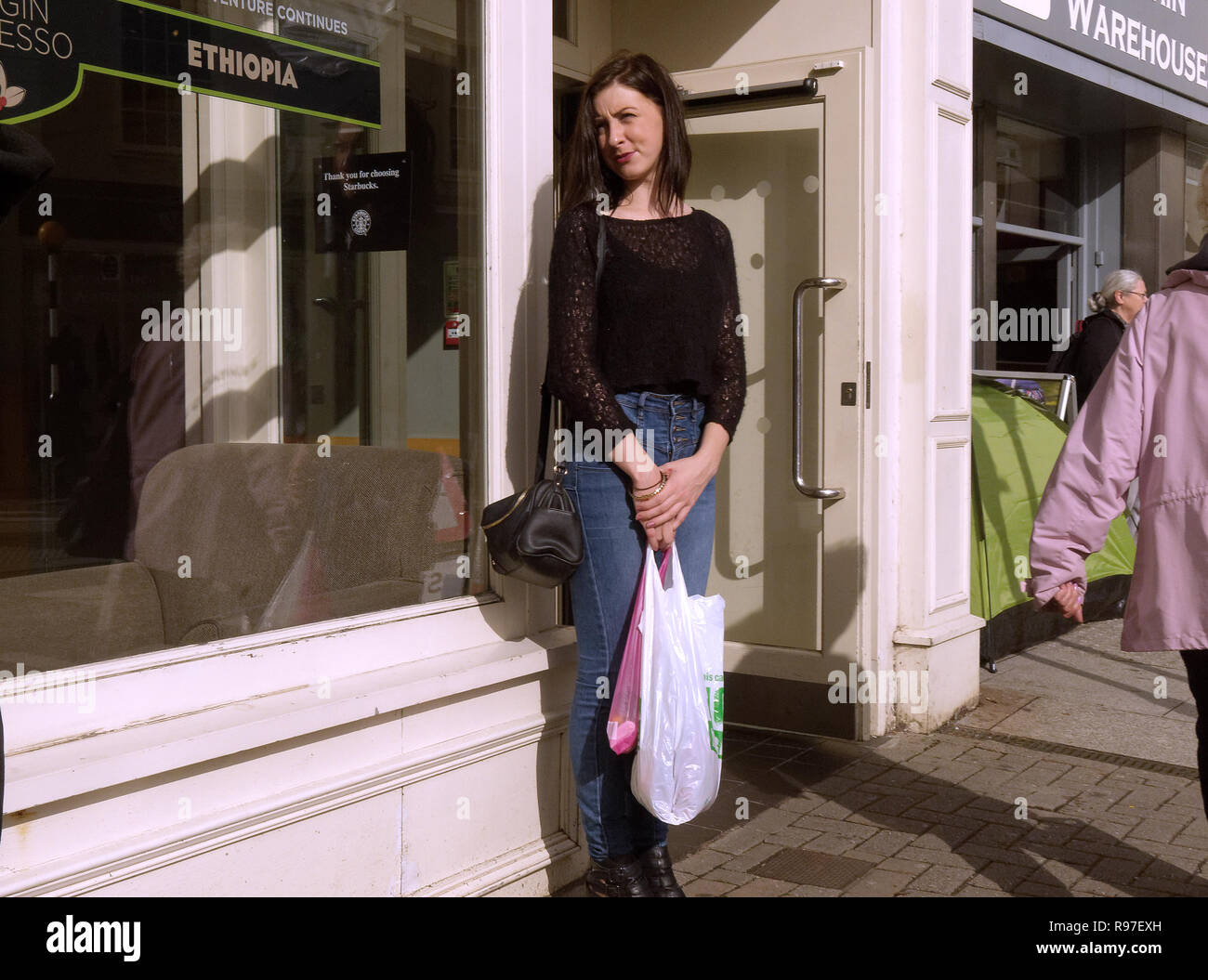 UK High street shoppers shopping and visitors browsing shop fronts ...