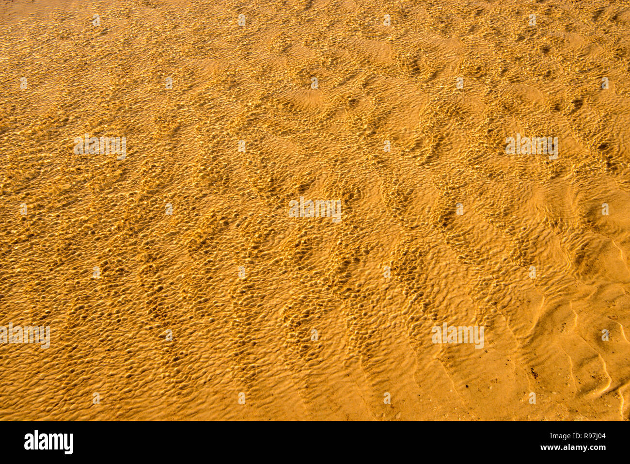 shallow surf with sand of a beach with patterns Stock Photo - Alamy