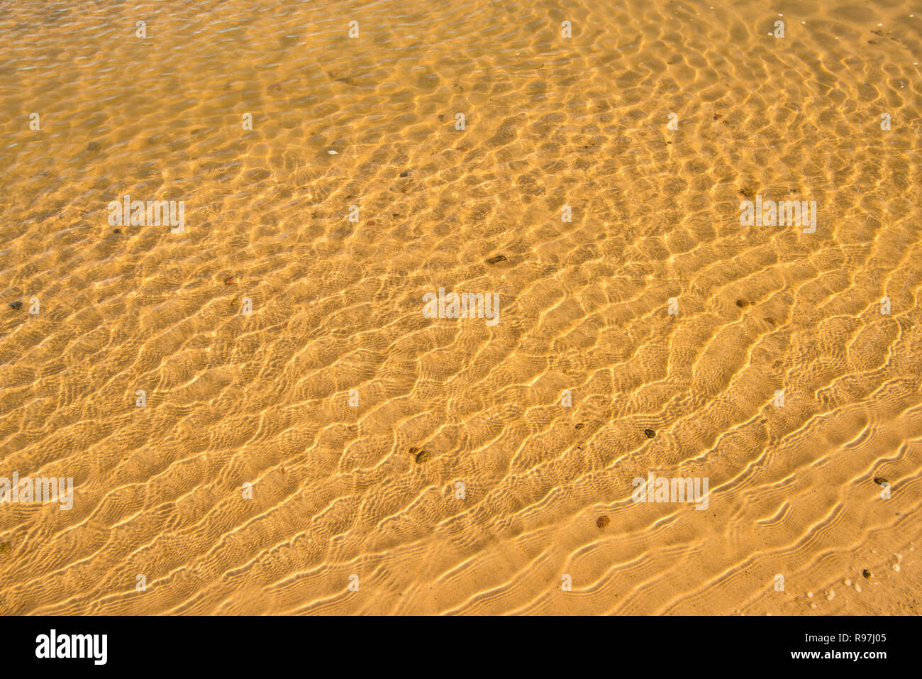 shallow surf with sand of a beach with patterns Stock Photo - Alamy