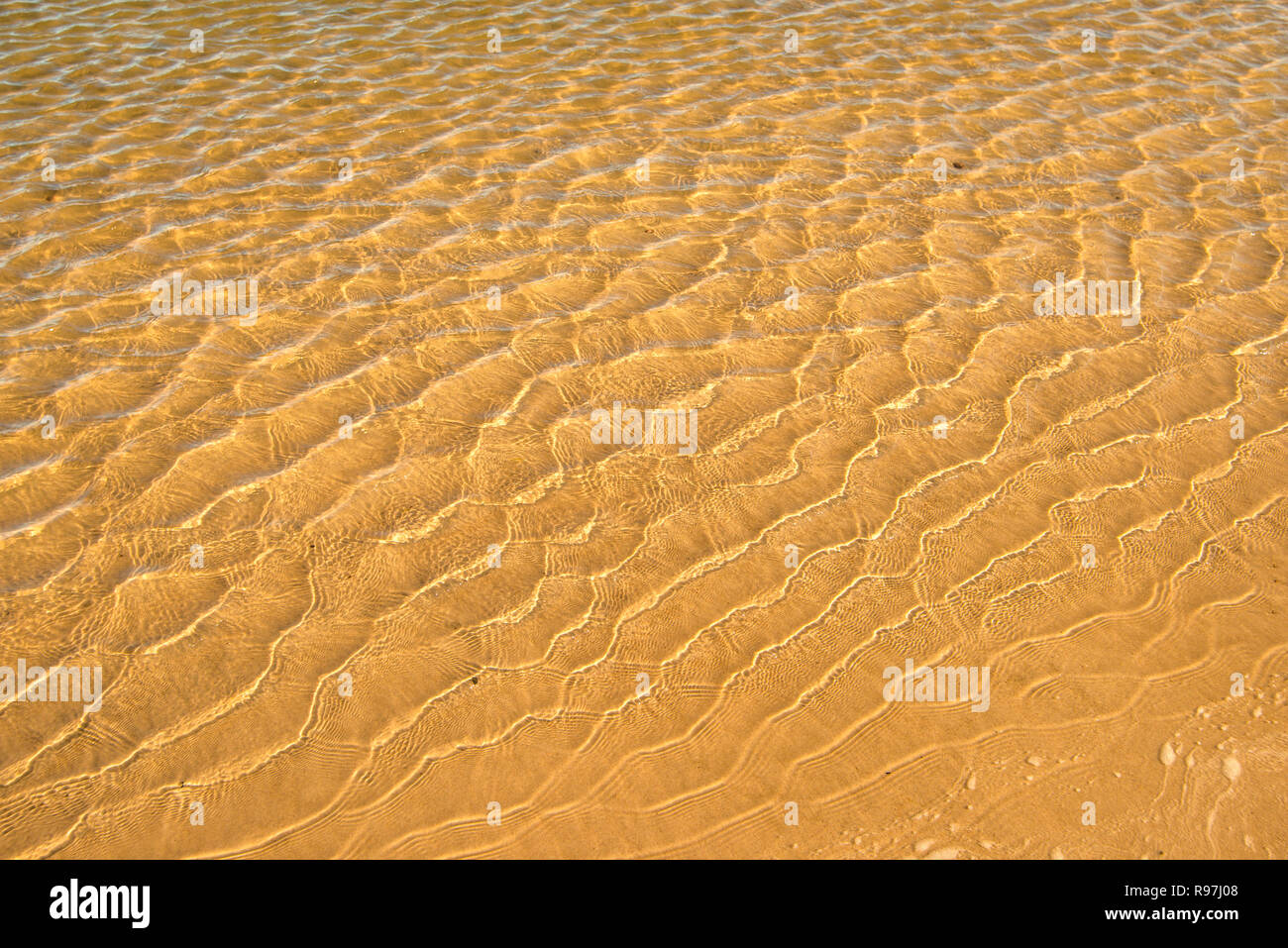 shallow surf with sand of a beach with patterns Stock Photo - Alamy