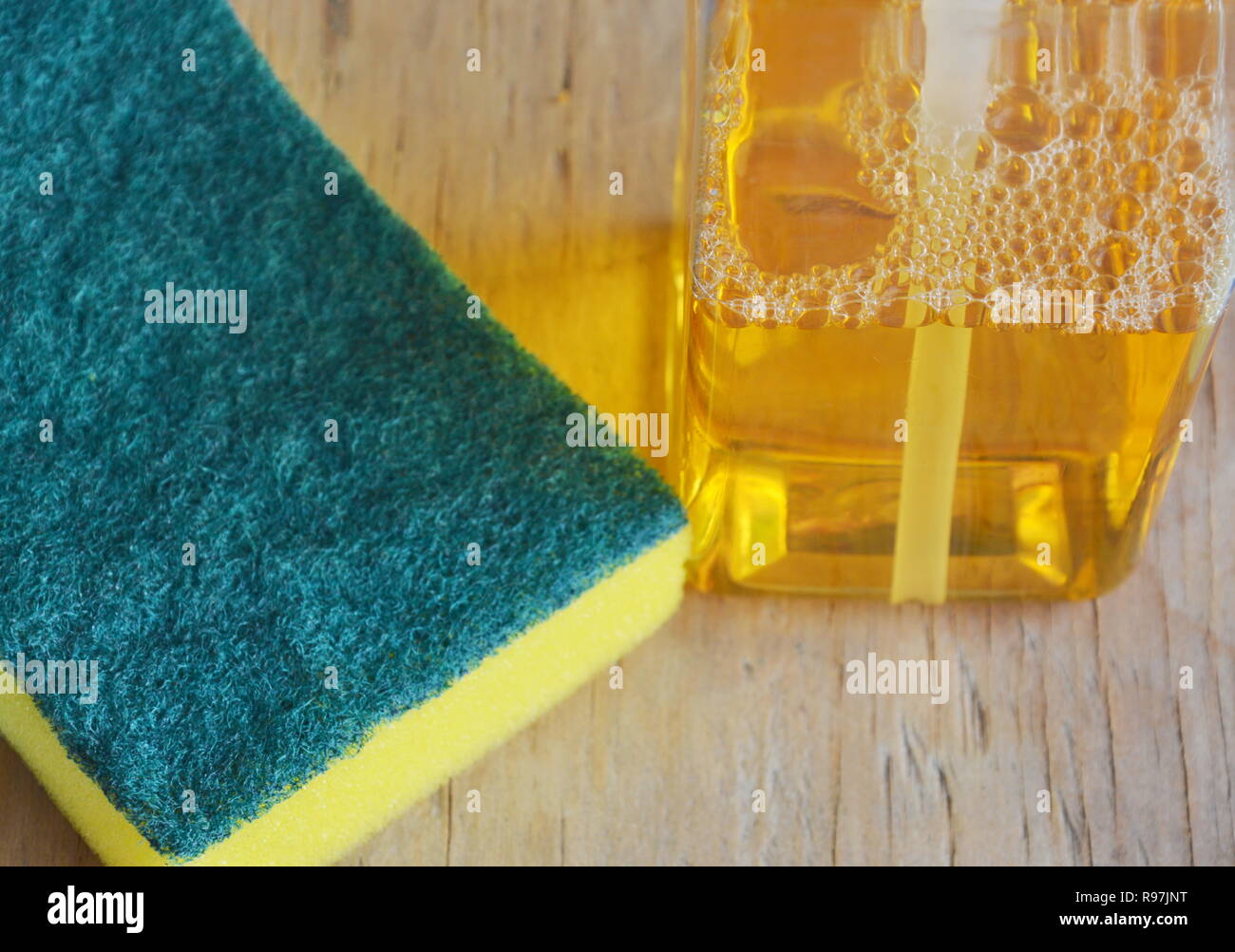 yellow dish washing soap and scrub sponge on wooden board Stock Photo ...