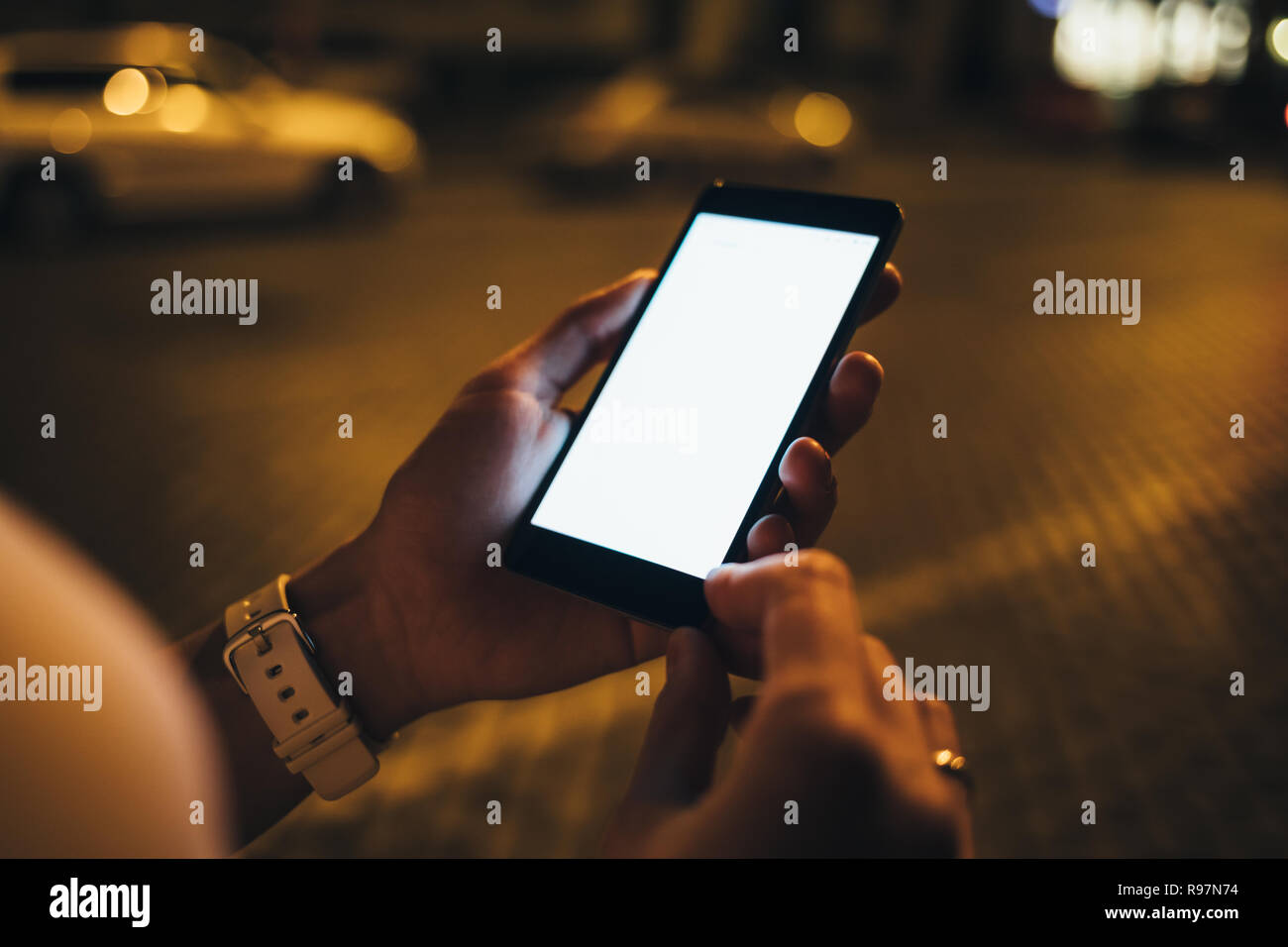Close-up young woman's hands holding mobile phone with blank white ...